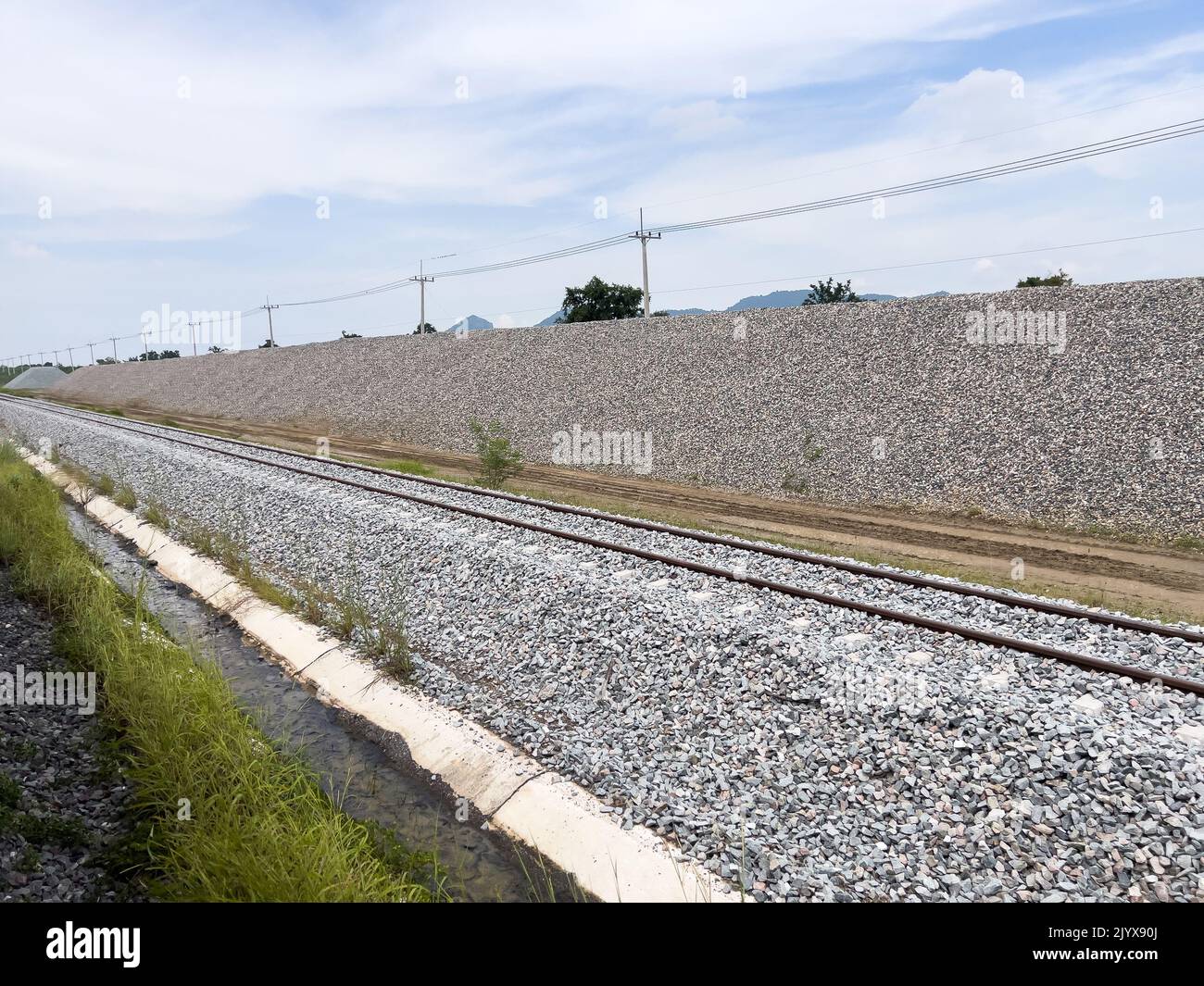 The large stone pile along the railway line for the construction of a ...