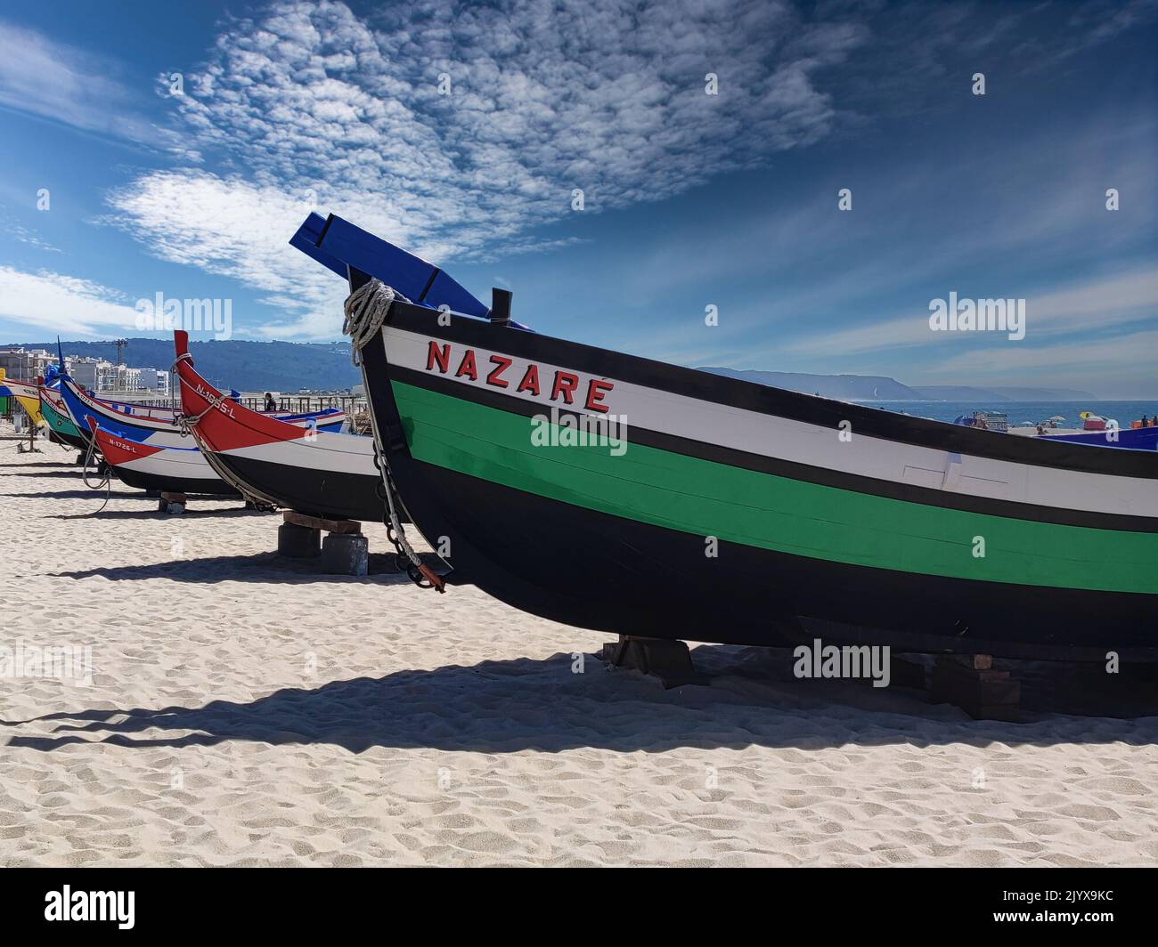 Old colorful fisherman boats displayed on the shore in Nazare, Portugal ...