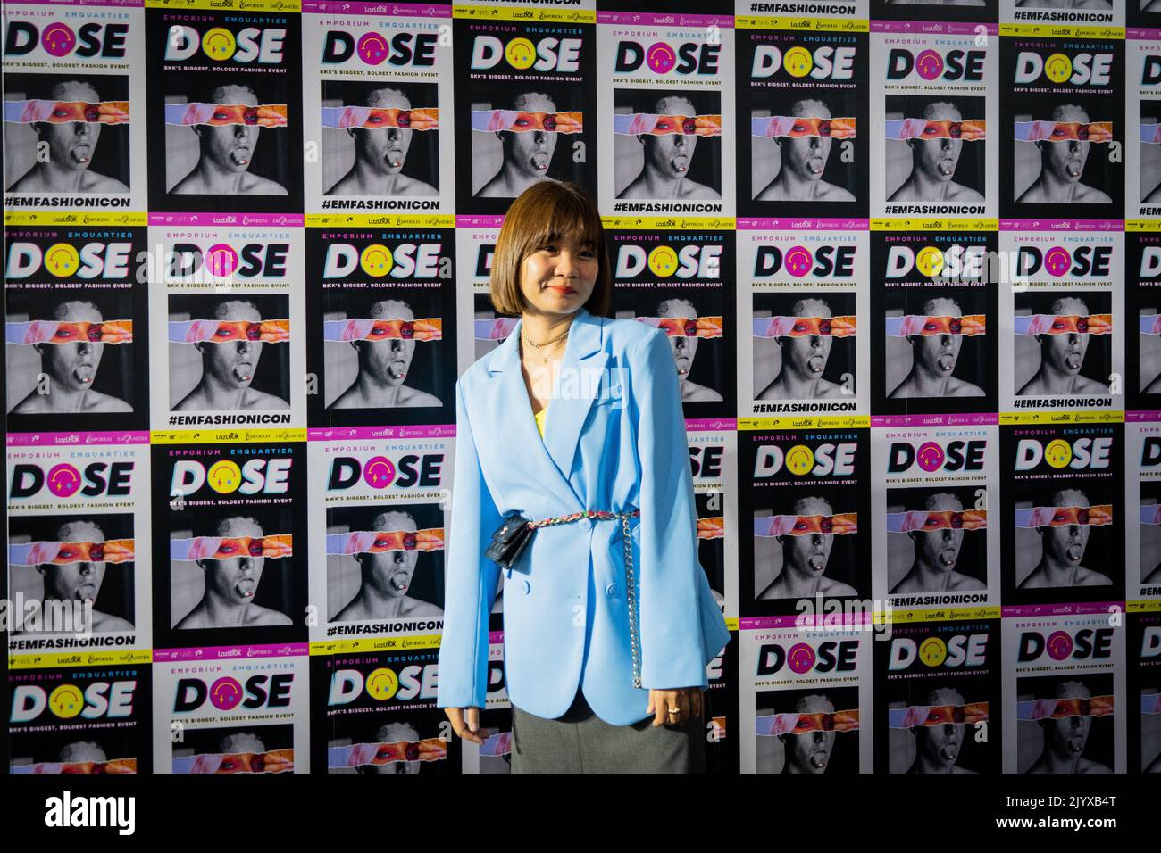 An attendee poses for a photo in front of the 'DOSE' entrance banner before the metaverse ...