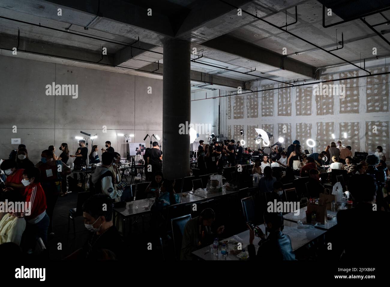 Models are seen getting prepared by makeup artists at stations outside ...