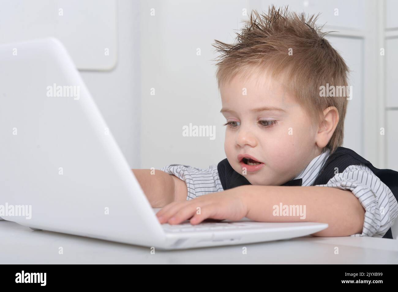 Little handsome boy sits with a computer Stock Photo - Alamy