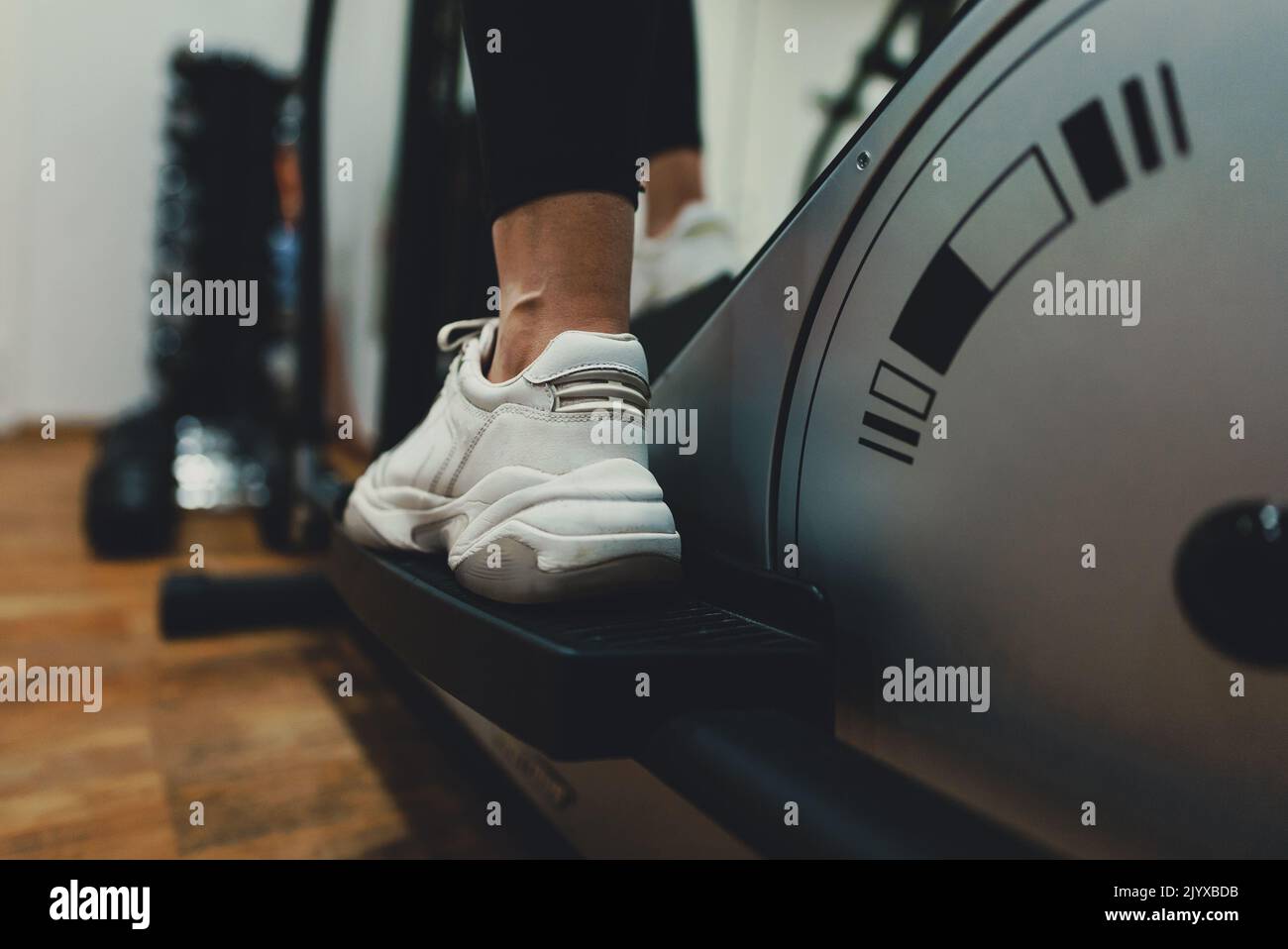 Woman training on elliptical trainer in gym Stock Photo - Alamy