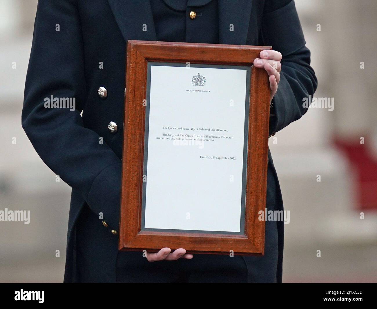 A member of royal household holds a notice at Buckingham Palace in ...