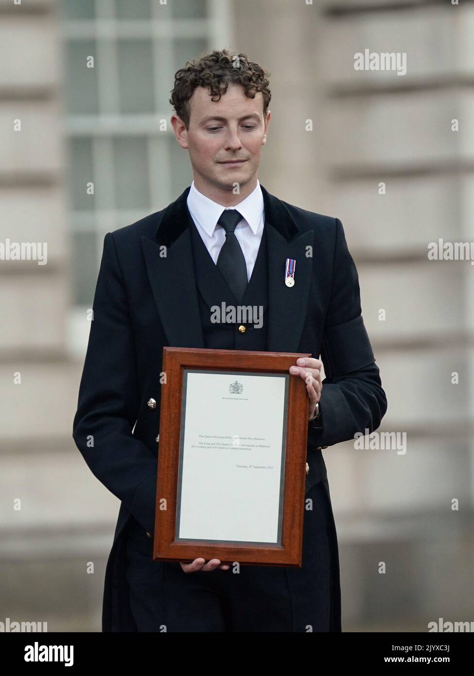 A member of royal household holds a notice at Buckingham Palace in ...