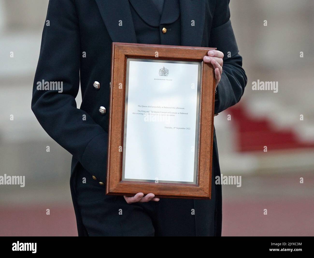 A member of royal household holds a notice at Buckingham Palace in ...
