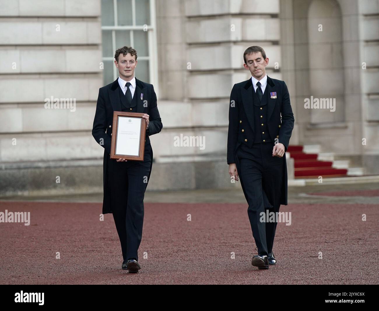 A member of royal household holds a notice at Buckingham Palace in ...