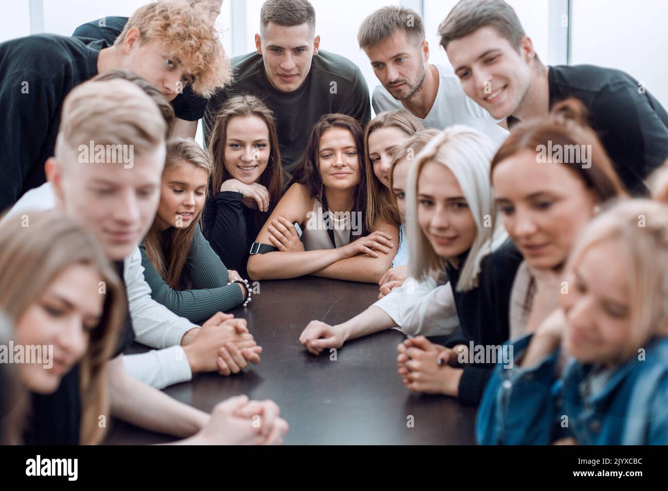 group of young people sitting at a large table Stock Photo - Alamy