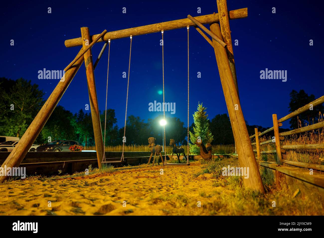 Wooden swing at night in the village Stock Photo - Alamy