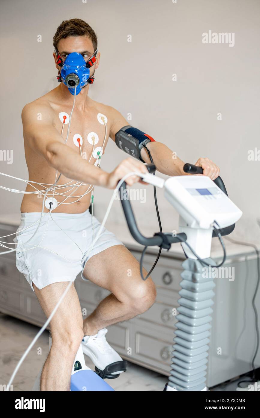 Man examining his cardiovascular system on bike simulator Stock Photo ...