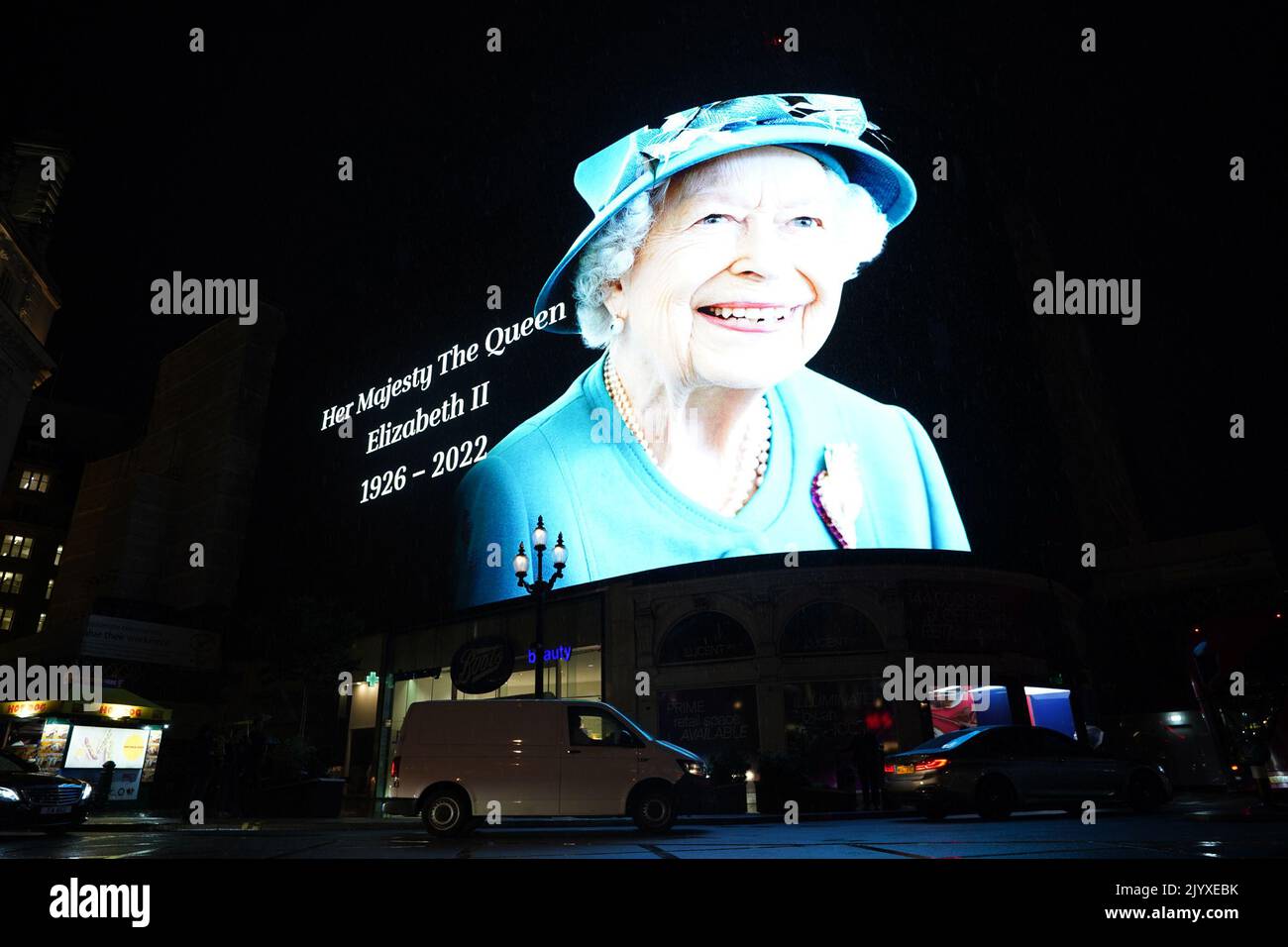 A tribute to Queen Elizabeth II is displayed on a big screen in ...