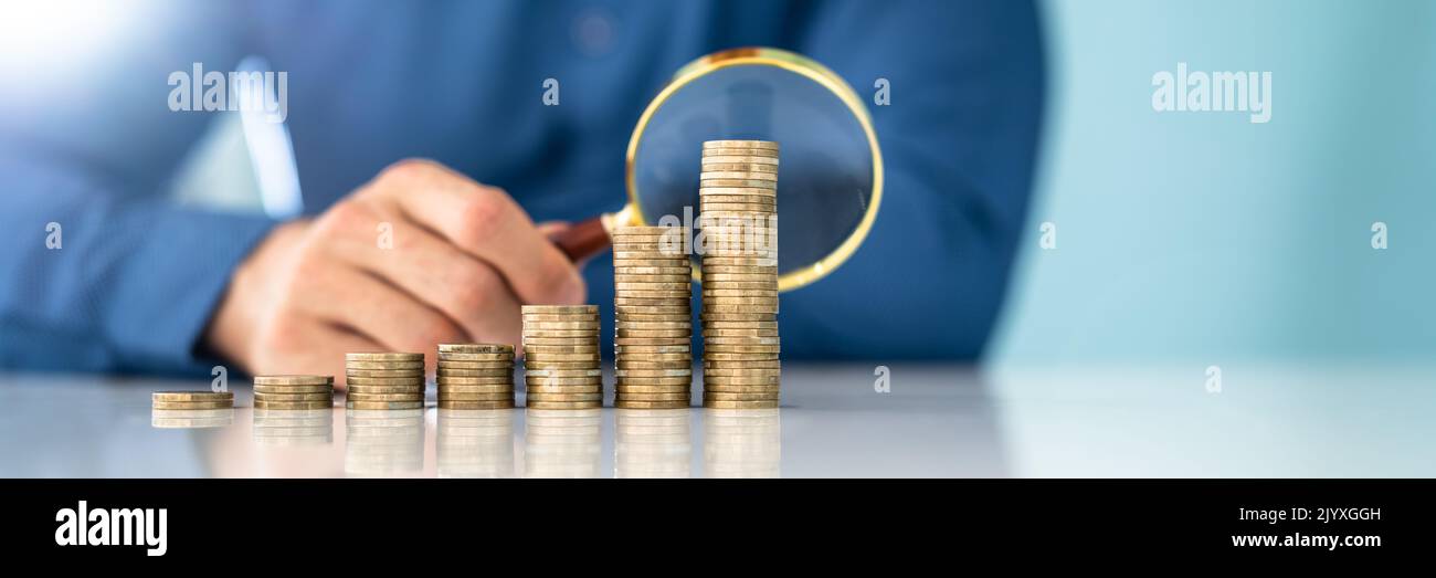 Analyze And Monitor Expenses With Magnifying Glass Stock Photo - Alamy