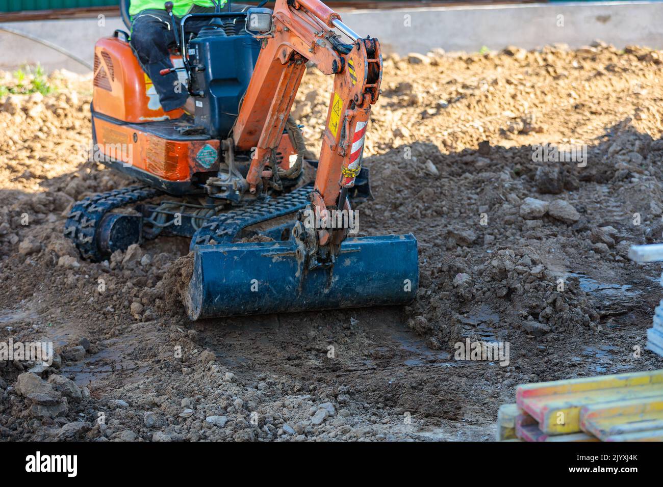 A minitractor rakes the earth with a bucket. Land works Stock Photo - Alamy