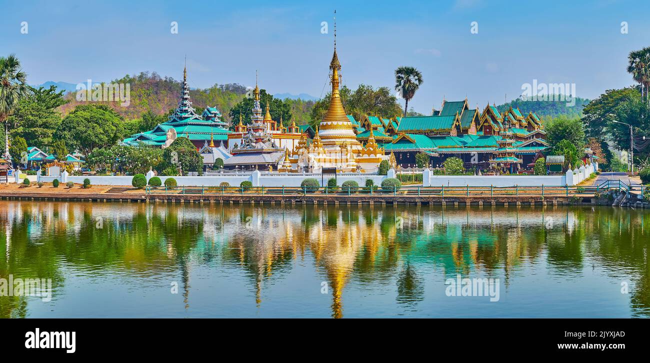 Panorama of the mirror surface of Nong Kham lake reflecting historic ...