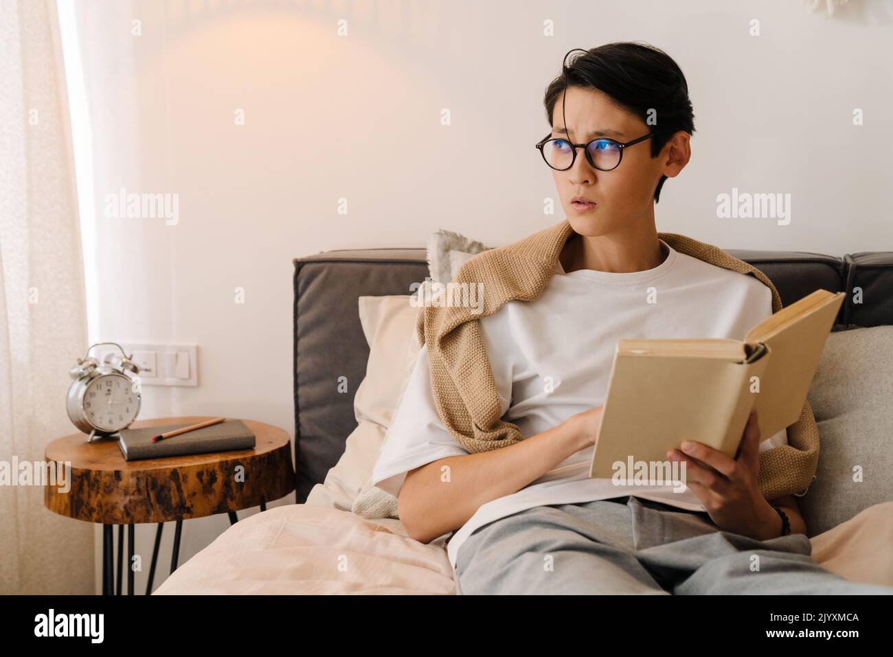 Asian teen boy reading book hi-res stock photography and images - Alamy