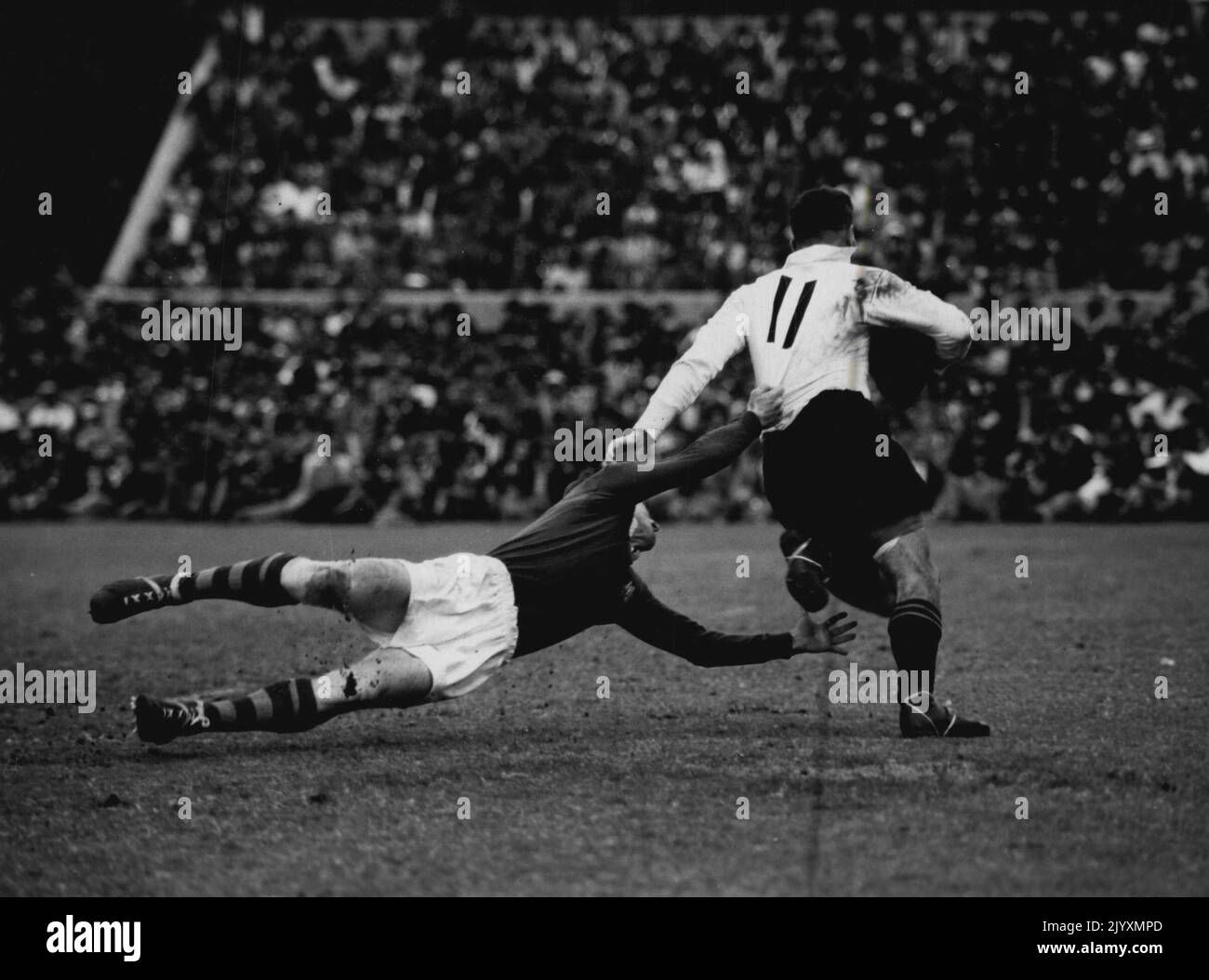 Dolf Bekker, the springbok right wing, eludes a dive-tackle by his ...