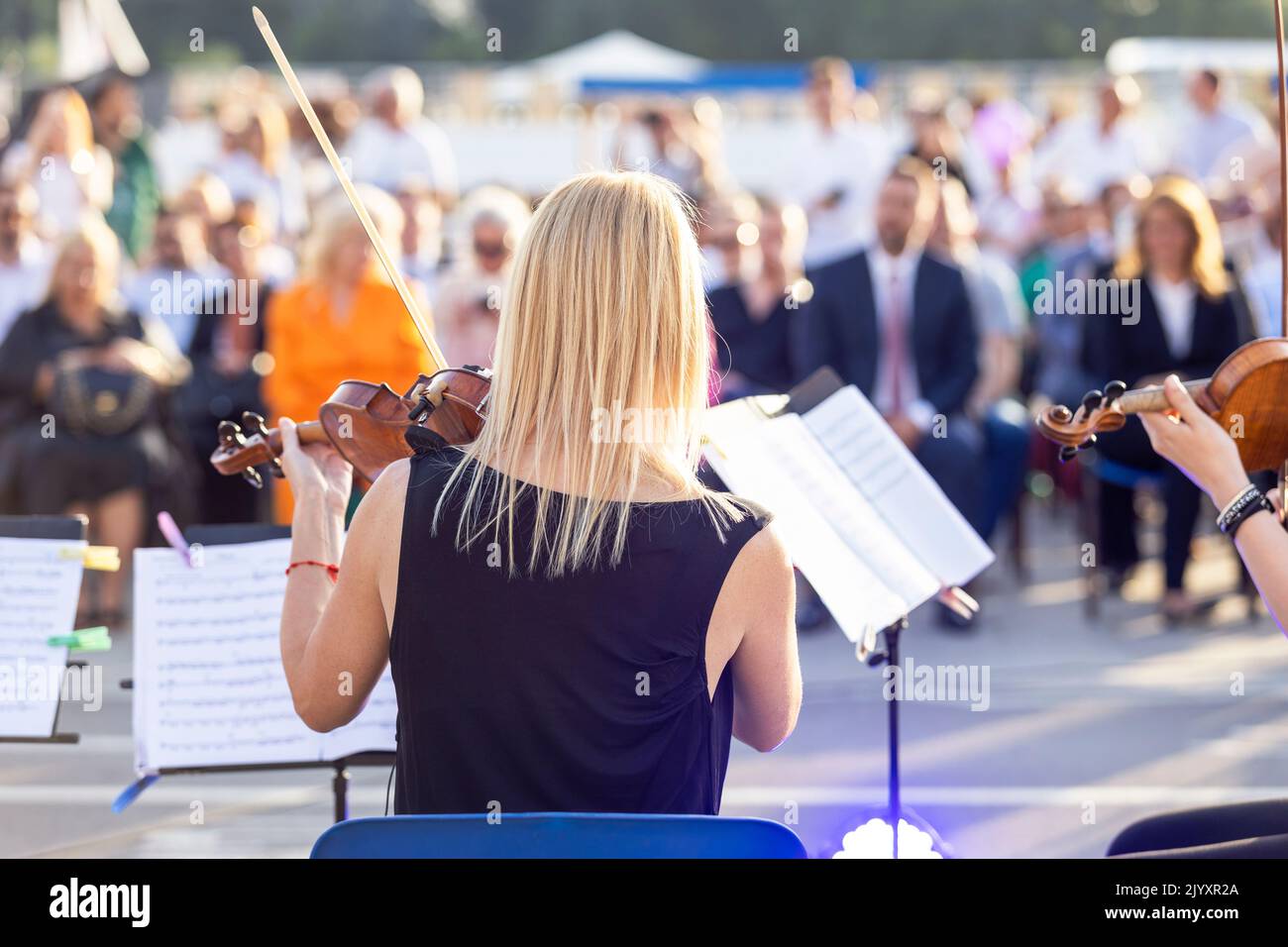 Female musician playing violin at classical music concert outdoors in ...