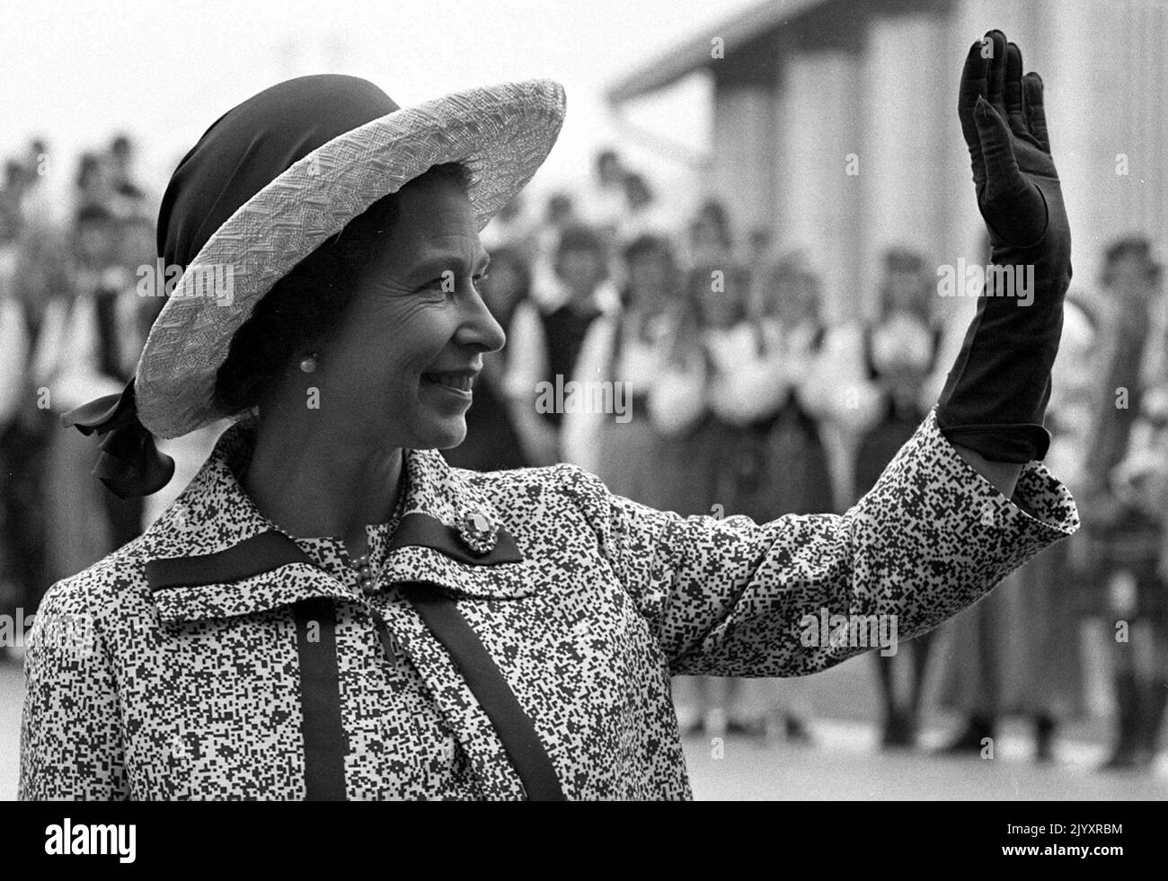A smiling Queen Elizabeth II waves to a happy crowd of on-lookers at ...