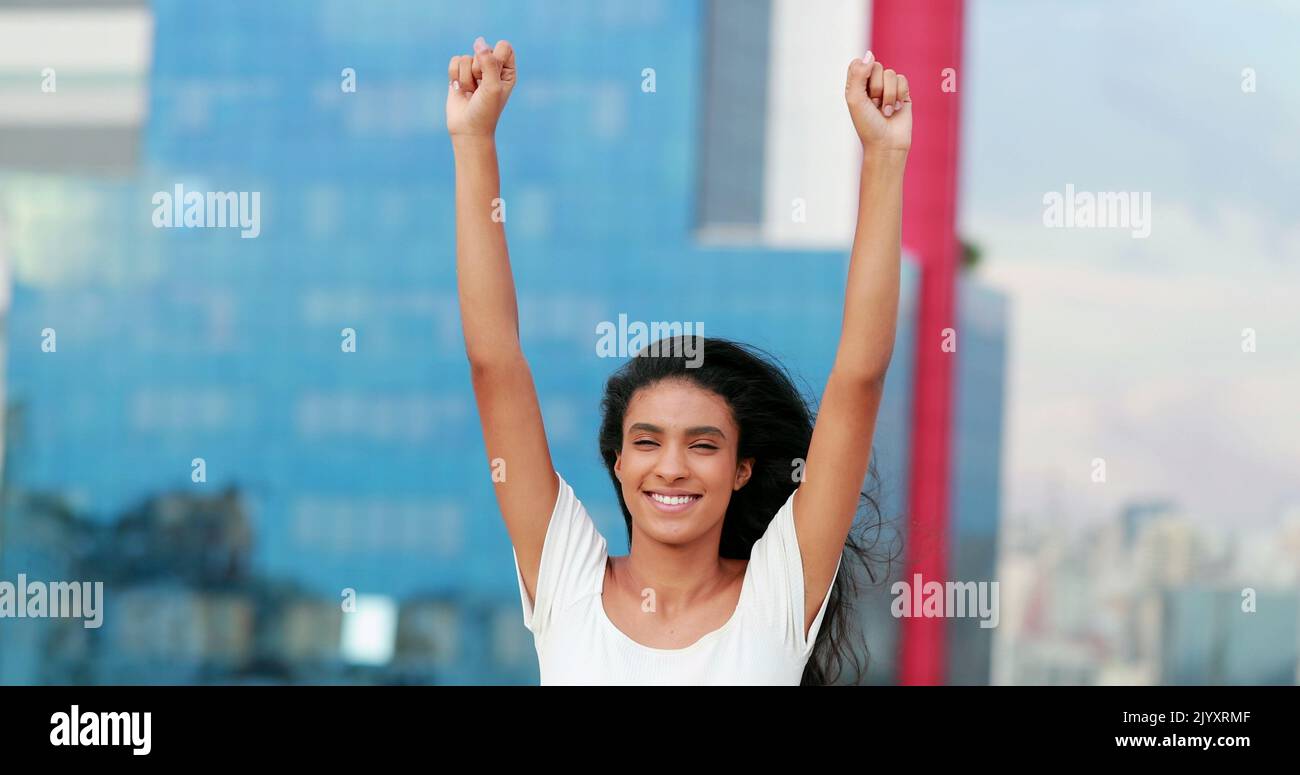 Young black woman raising arms in the air expressing victory feeling ...