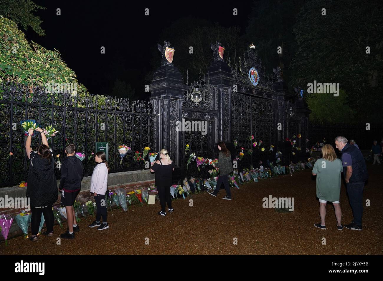 People lay flowers and pay their respects at the gate of Sandringham ...