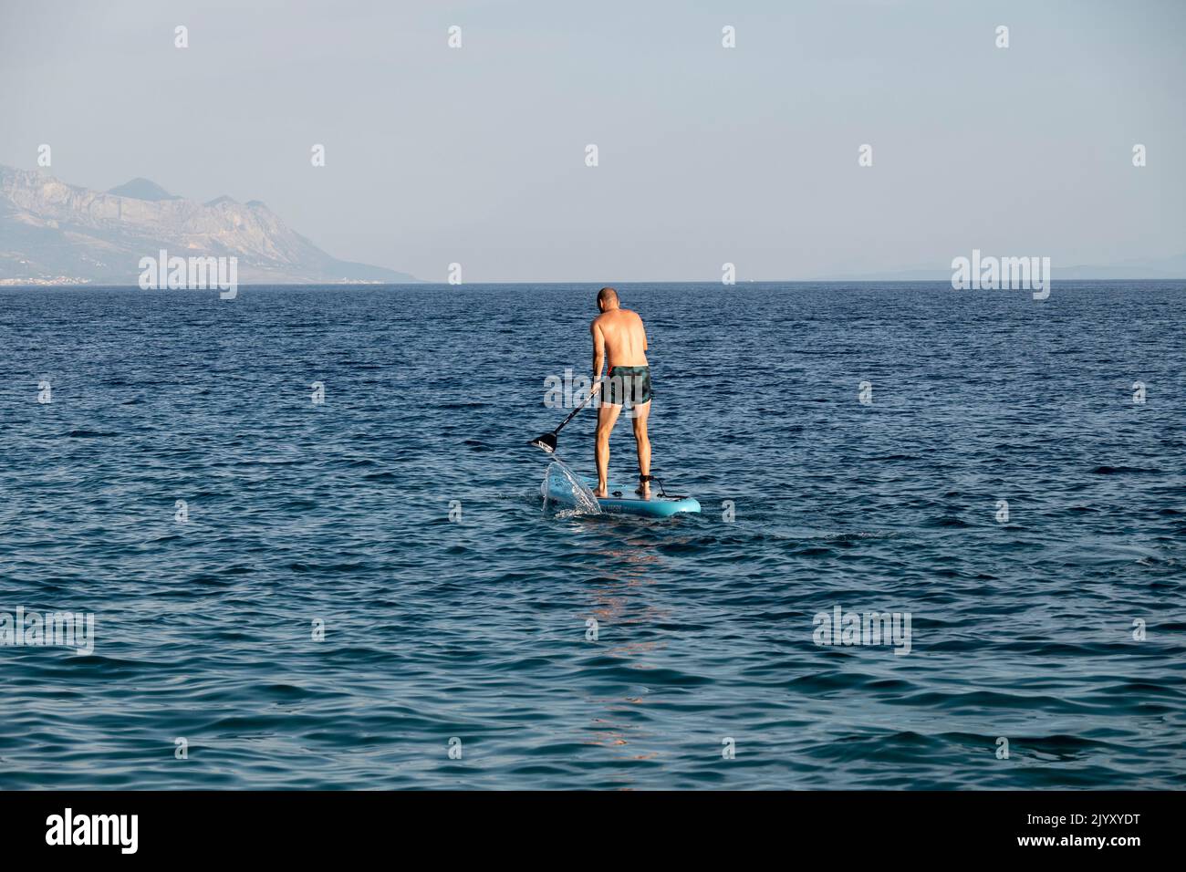 Mimice, Croatia-August 16th, 2022: Man standing and rowing on his ...