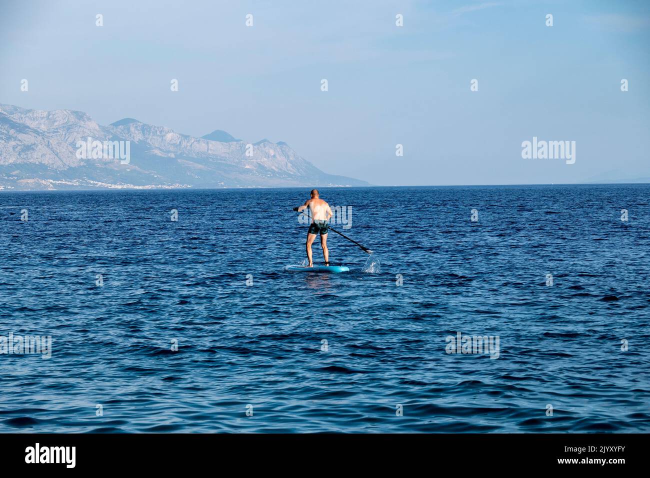 Mimice, Croatia-August 16th, 2022: Man standing and rowing on his ...