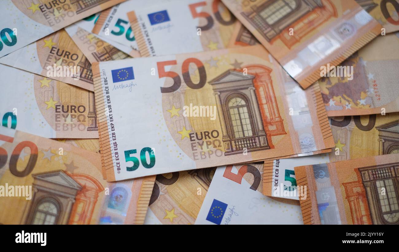 The background consists of many euro banknotes of different ...