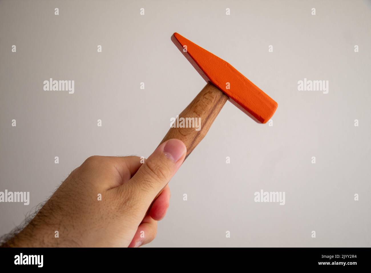 Hand held wooden handle hammer and orange head, isolated white ...