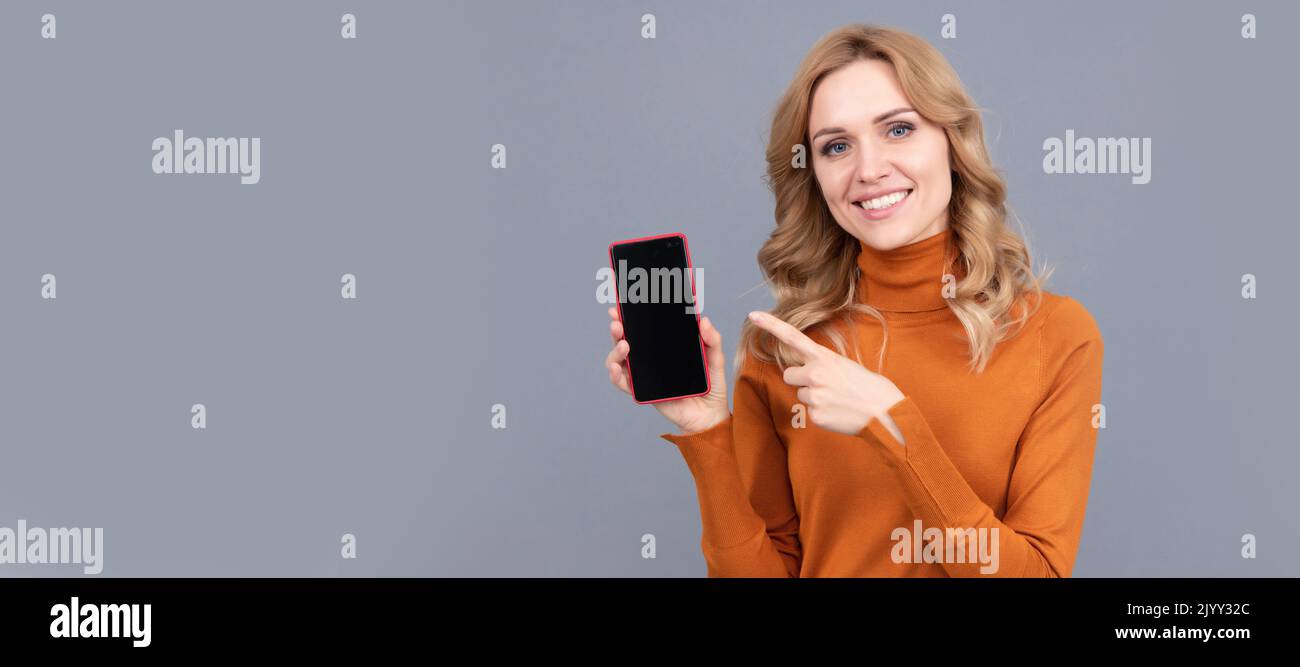 Happy girl pointing finger at mobile phone. Pointing index finger for ...