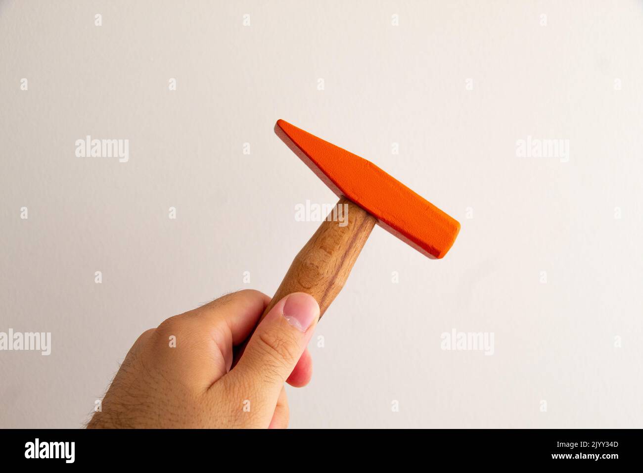 Hand held wooden handle hammer and orange head, isolated white ...