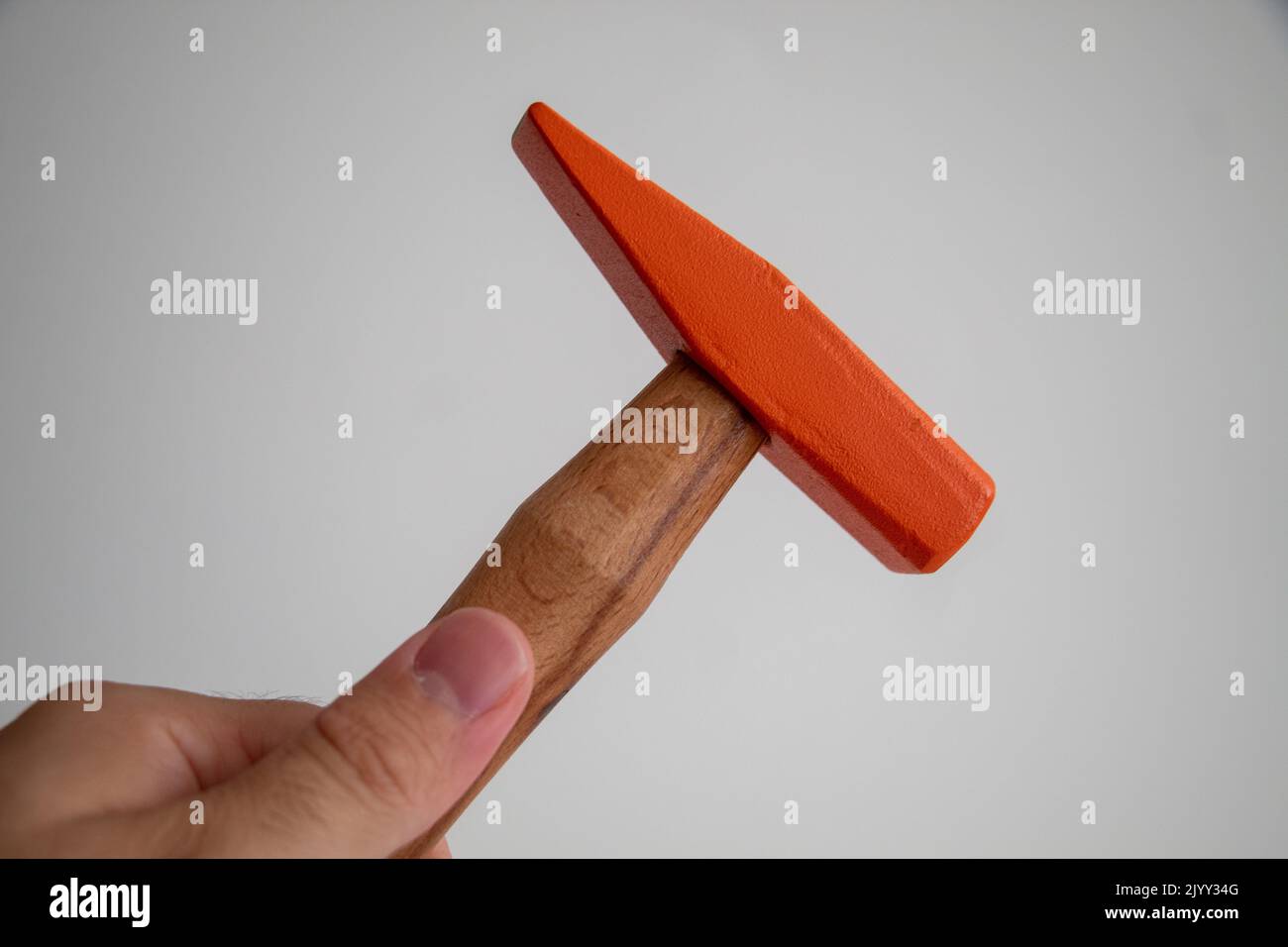 Hand held wooden handle hammer and orange head, isolated white ...