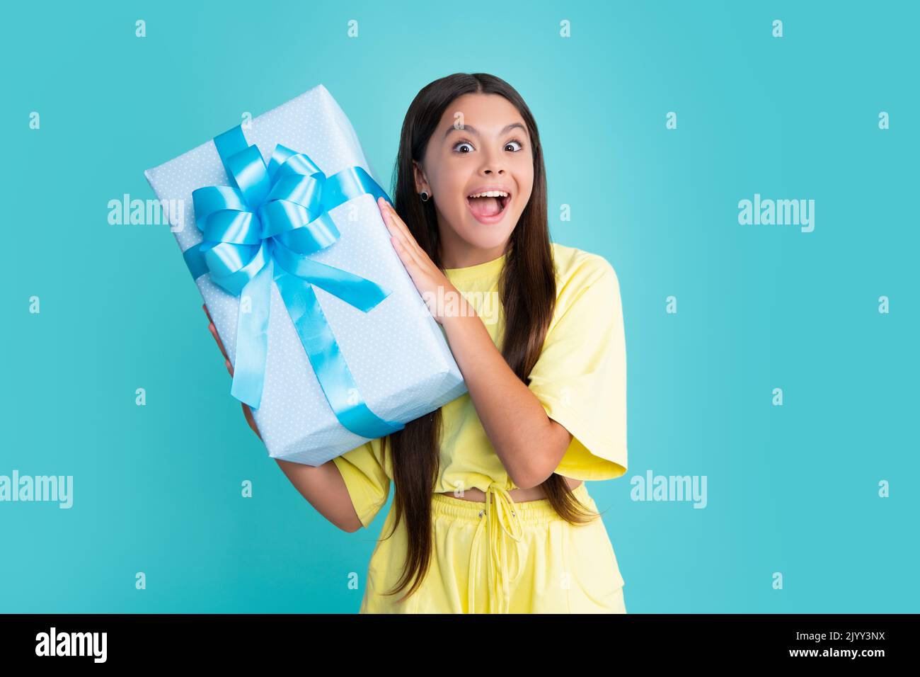 Child with gift present box on isolated studio background. Gifting for ...