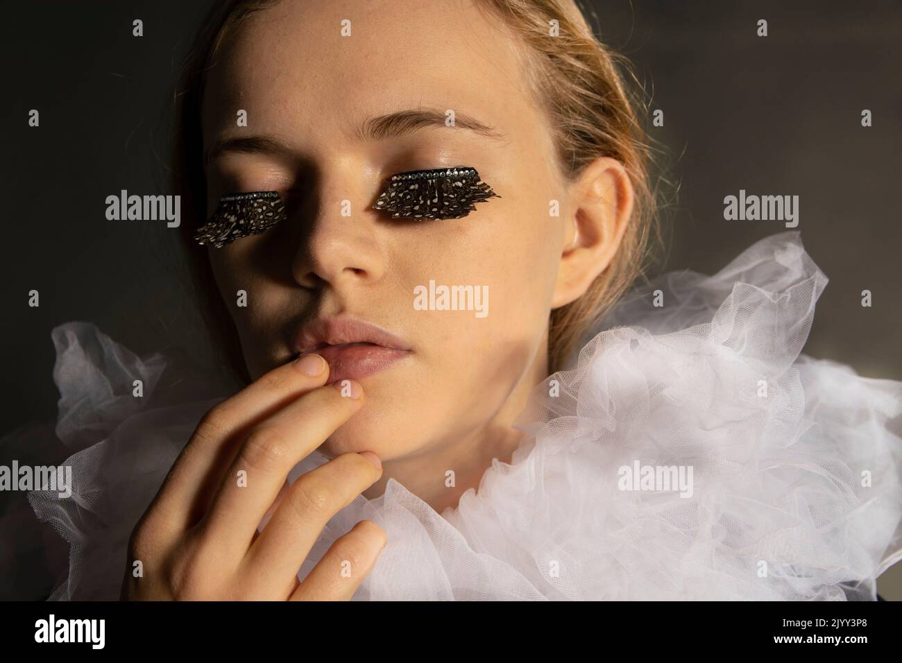 Blonde girl with clown ruffle white collar and spotty false eyleashes ...