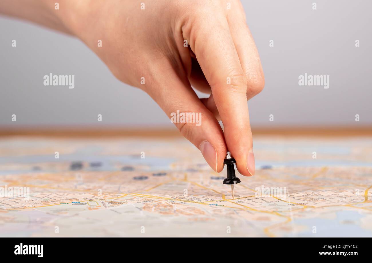 Hand pushing pin on map. Trip planning. Woman marking travel ...