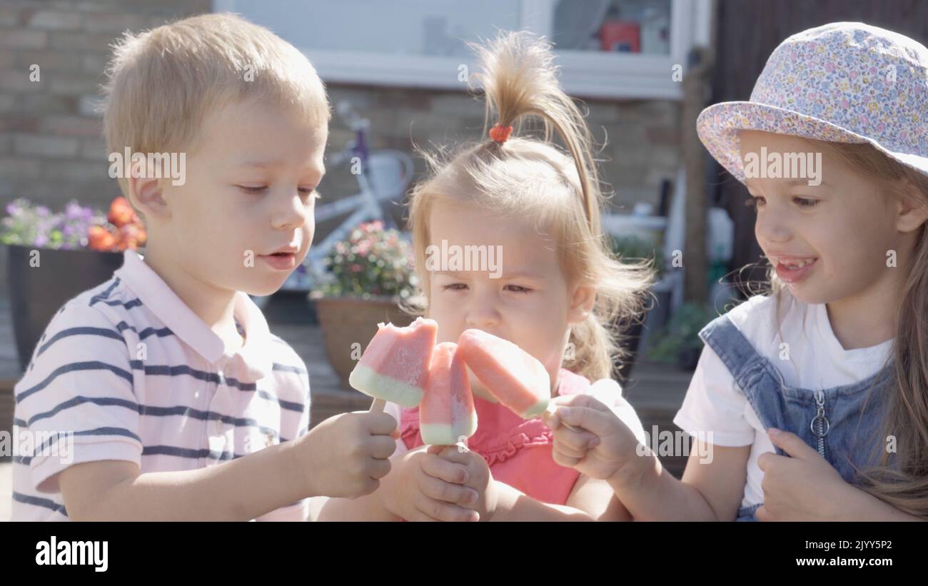 Three cute little Children enjoys delicious ice cream cone. Child ...