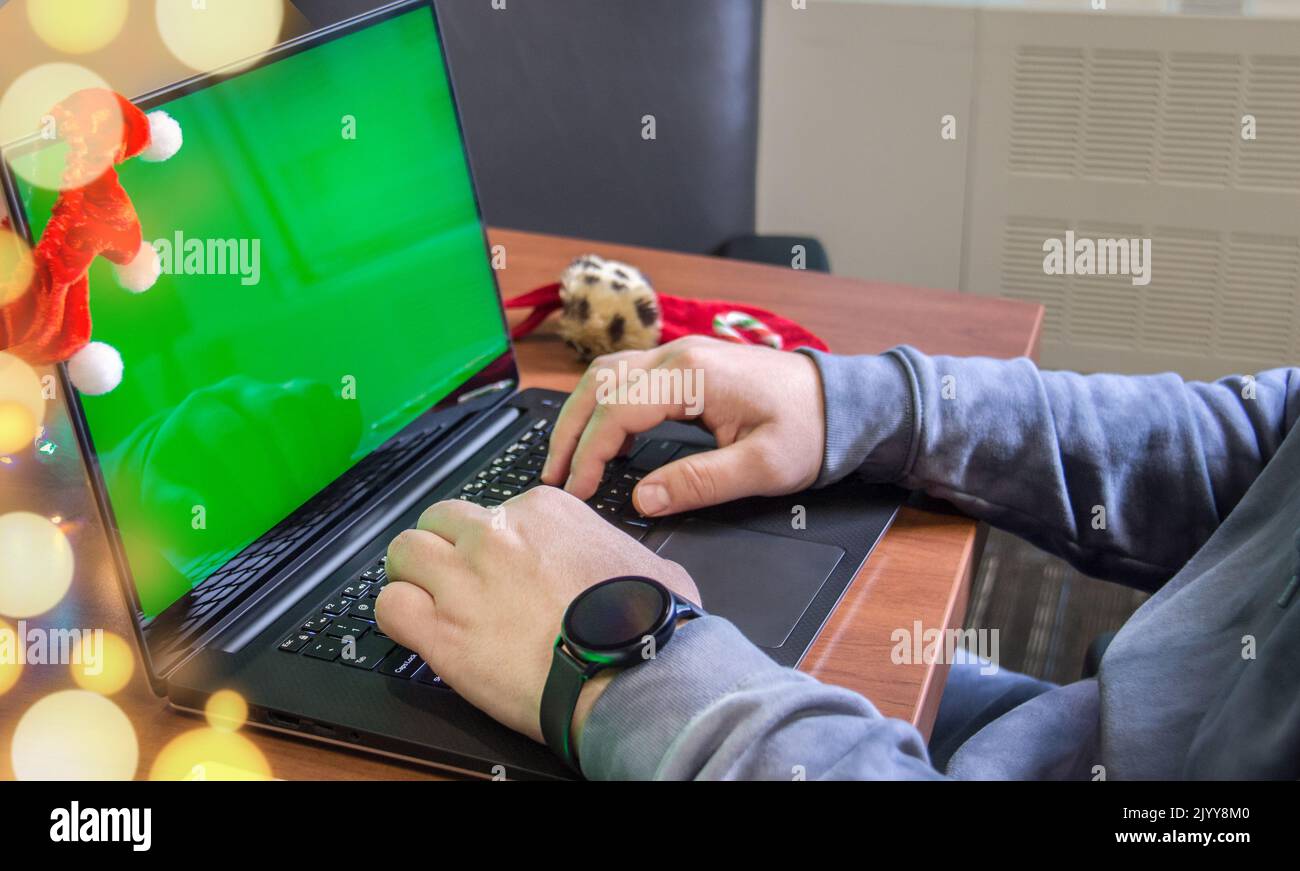 Closeup man hands typing on laptop keyboard with empty green screen and ...