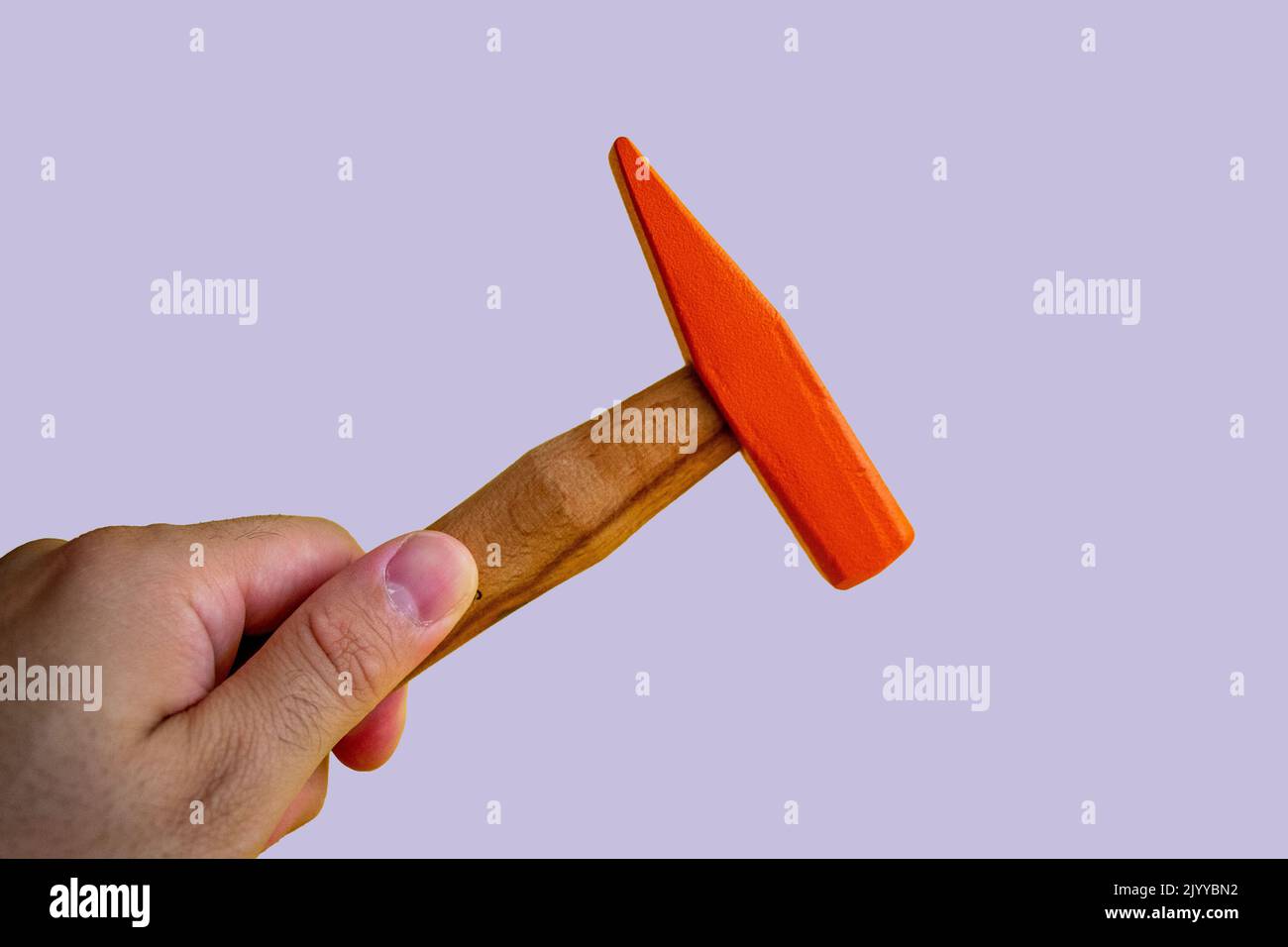 Hand held wooden handle hammer and orange head, isolated blue ...