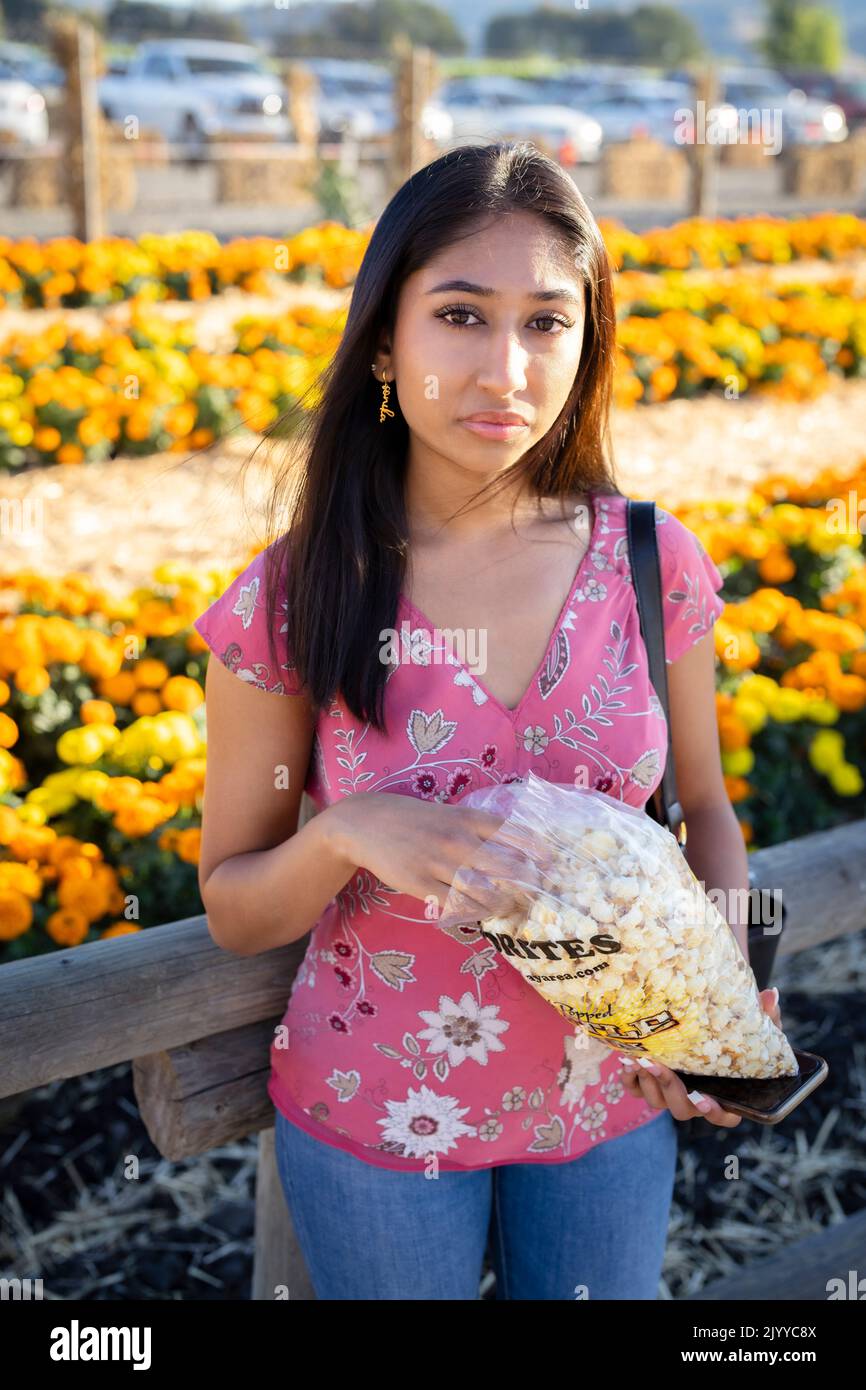 Fall Celebration Portrait of Young Asian Woman Standing in Front of a Field of Orange and Yellow ...