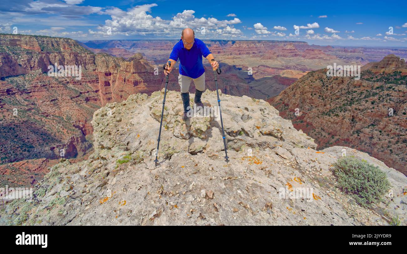 A hiker climbing on the edge of a cliff along Buggeln Hill Trail ...