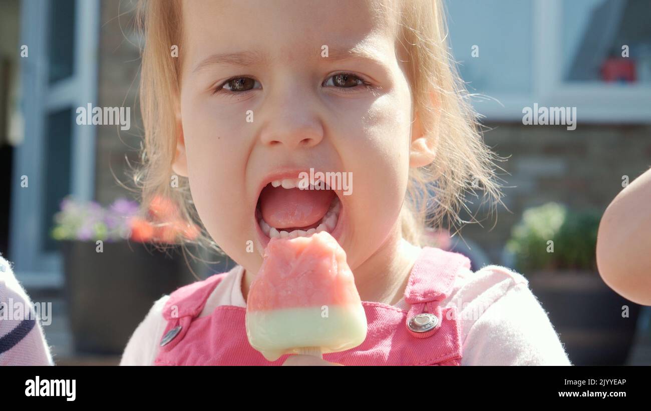 Close up portrait Girl enjoys delicious ice cream cone. Child eating ...