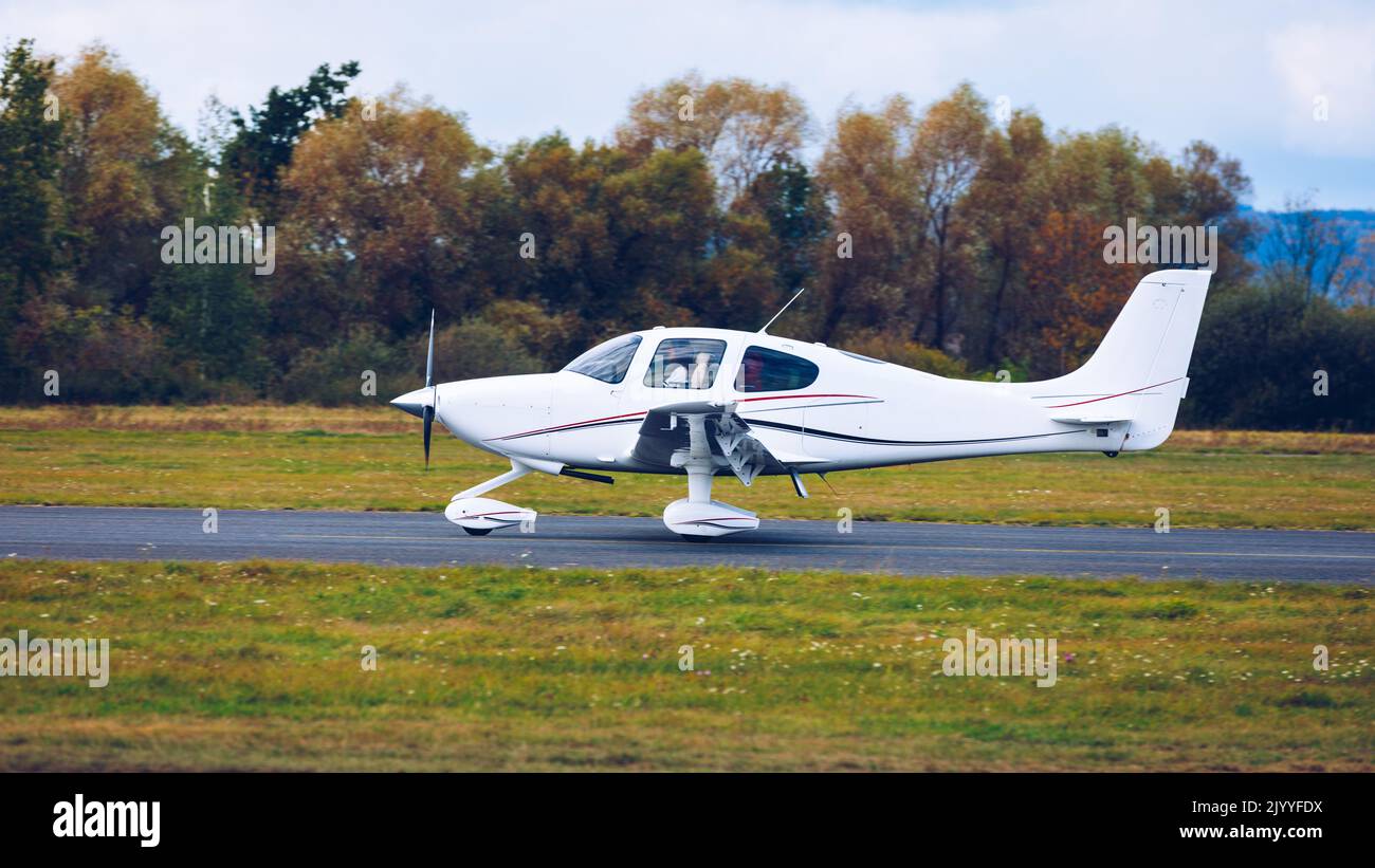 Light small plane flies against the background of a forest not high ...
