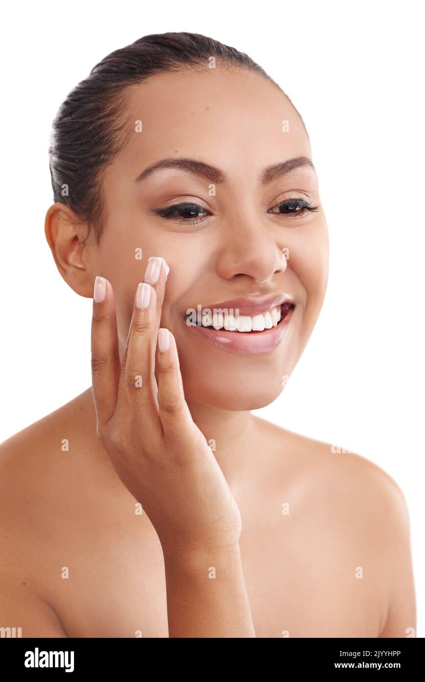 Giving her skin the moisture it needs. Studio shot of a beautiful young ...