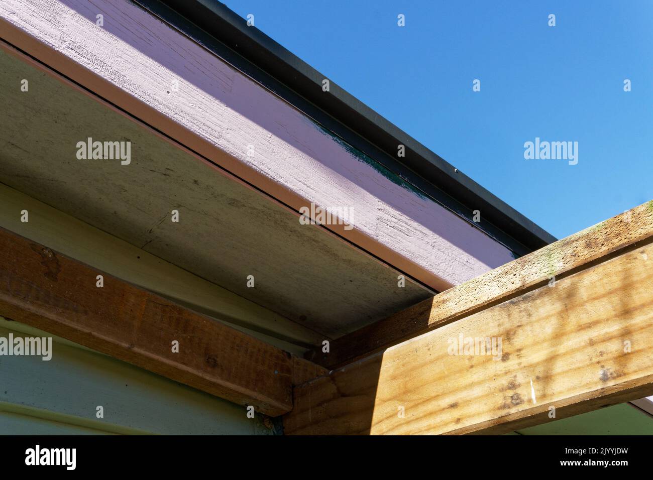 Repaired barge boards painted with primer, renovating an old wooden ...