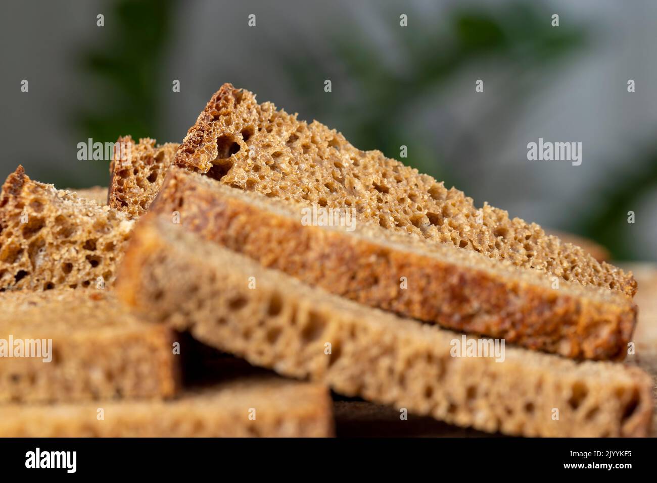 Sliced piece of black rye bread on a board, cutting black bread from ...
