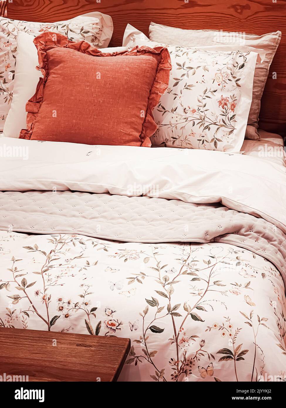 Vintage countryside style bedding with floral pattern on wooden bed in ...