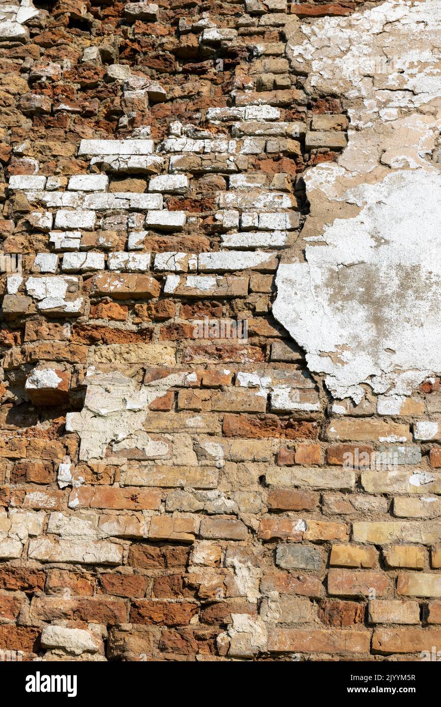 An old brick wall with various damages, the wall is old and made of ...