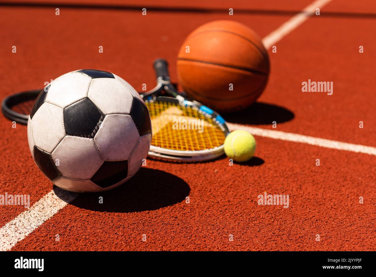 A group of sports equipment on black background including tennis ...