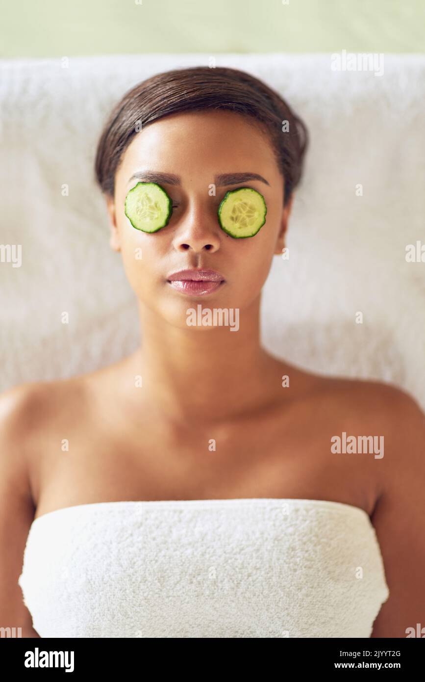 Everyone deserves a break, even your eyes do. a young woman with cucumber slices over her eyes ...