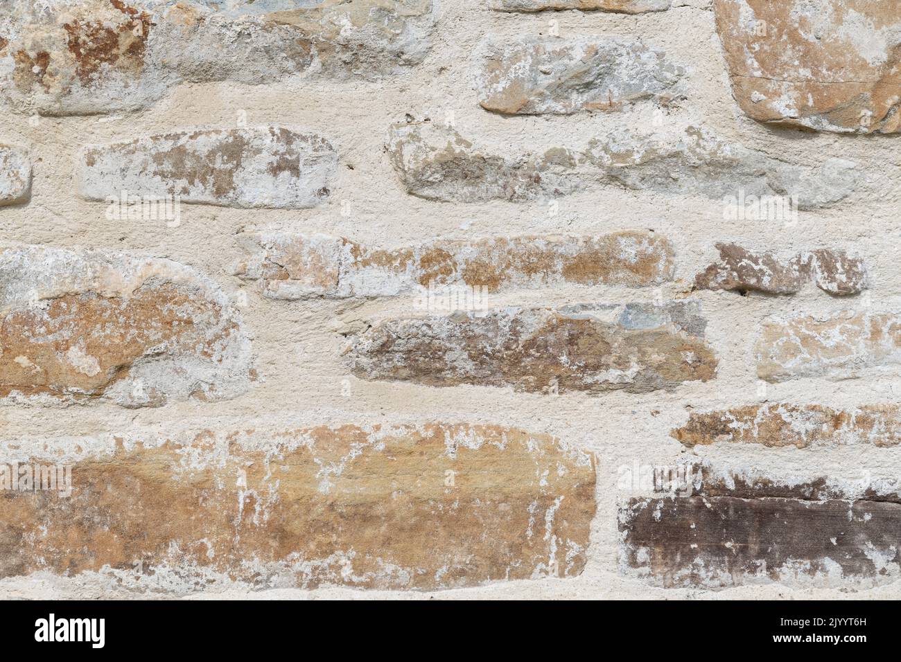 Close up of old stone wall with thick grout and rough textured surface ...