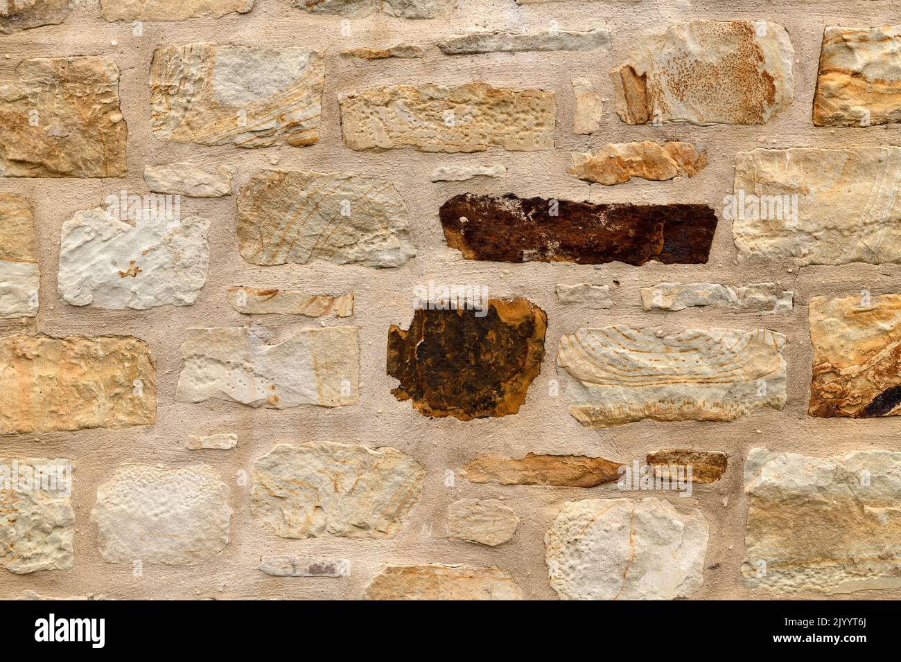 Close up of old stone wall with thick grout and rough textured surface ...