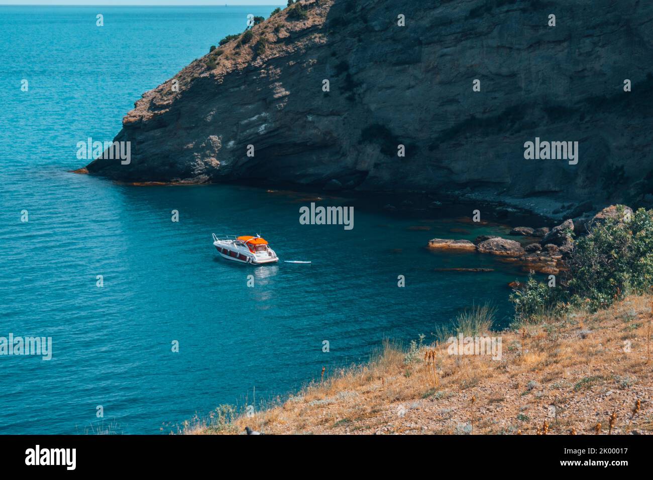 Orange yacht in a beautiful azure bay Stock Photo - Alamy